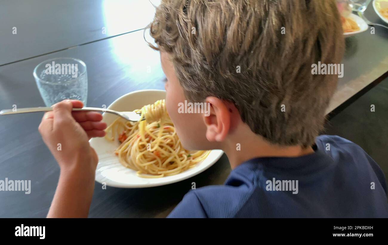 Young boy eating pasta. Child eats spaghetti Stock Photo - Alamy