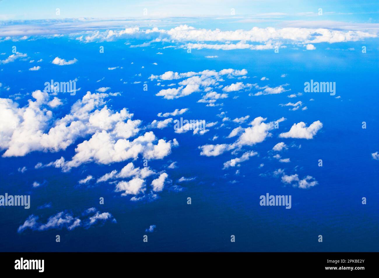 blue sky with cumulus clouds from an airplane window over the pacific ...