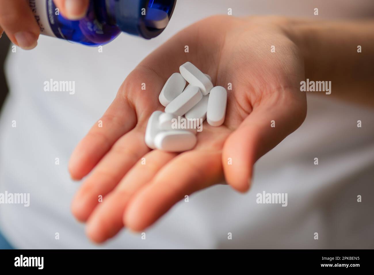 Close-up Female hands holding White Pills Calcium Capsule in hand and ...