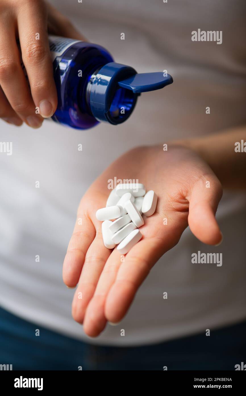 Close-up Female hands holding White Pills Calcium Capsule in hand and ...