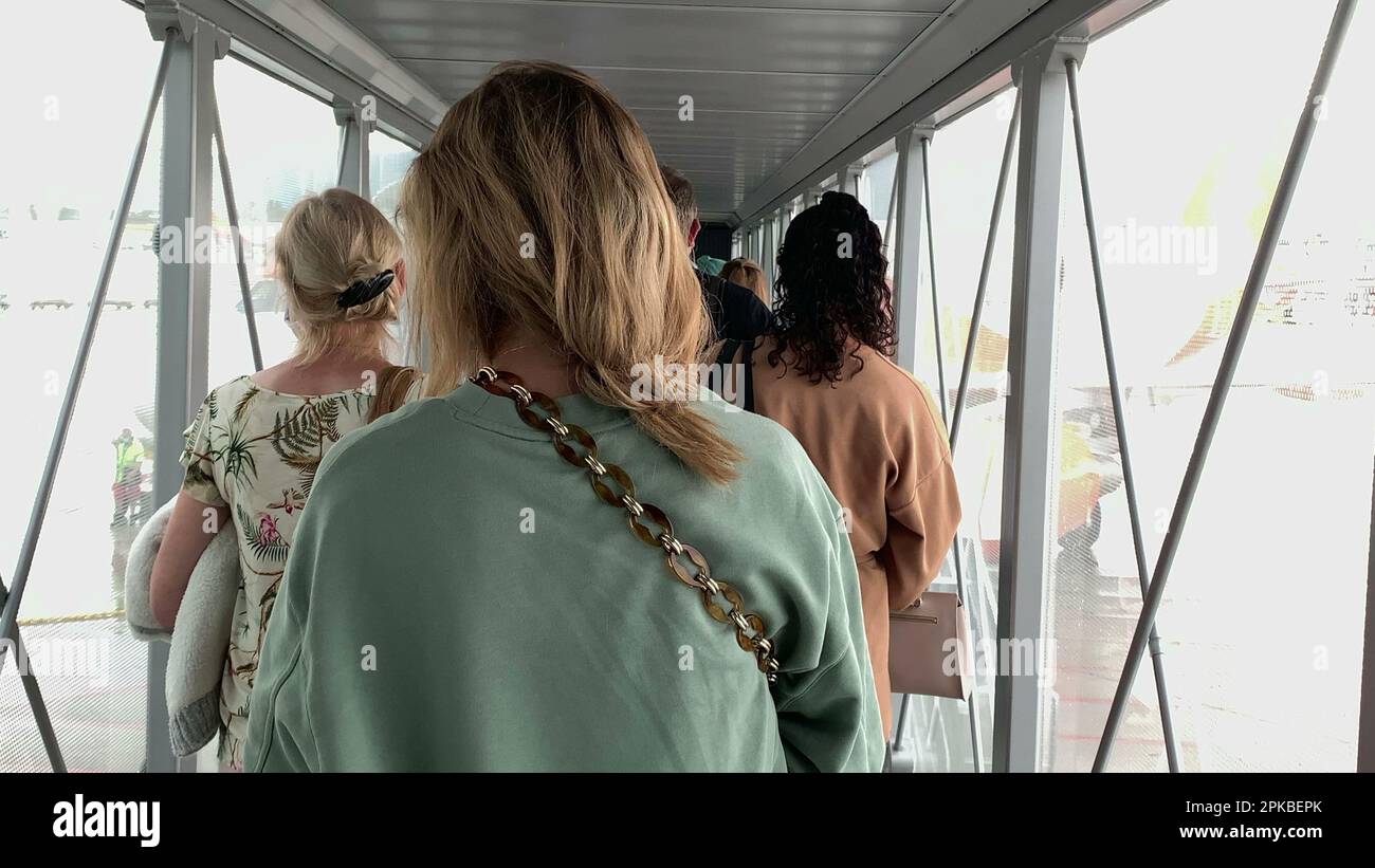 Passengers boarding plane at bridge. Crowd people standing waiting to ...