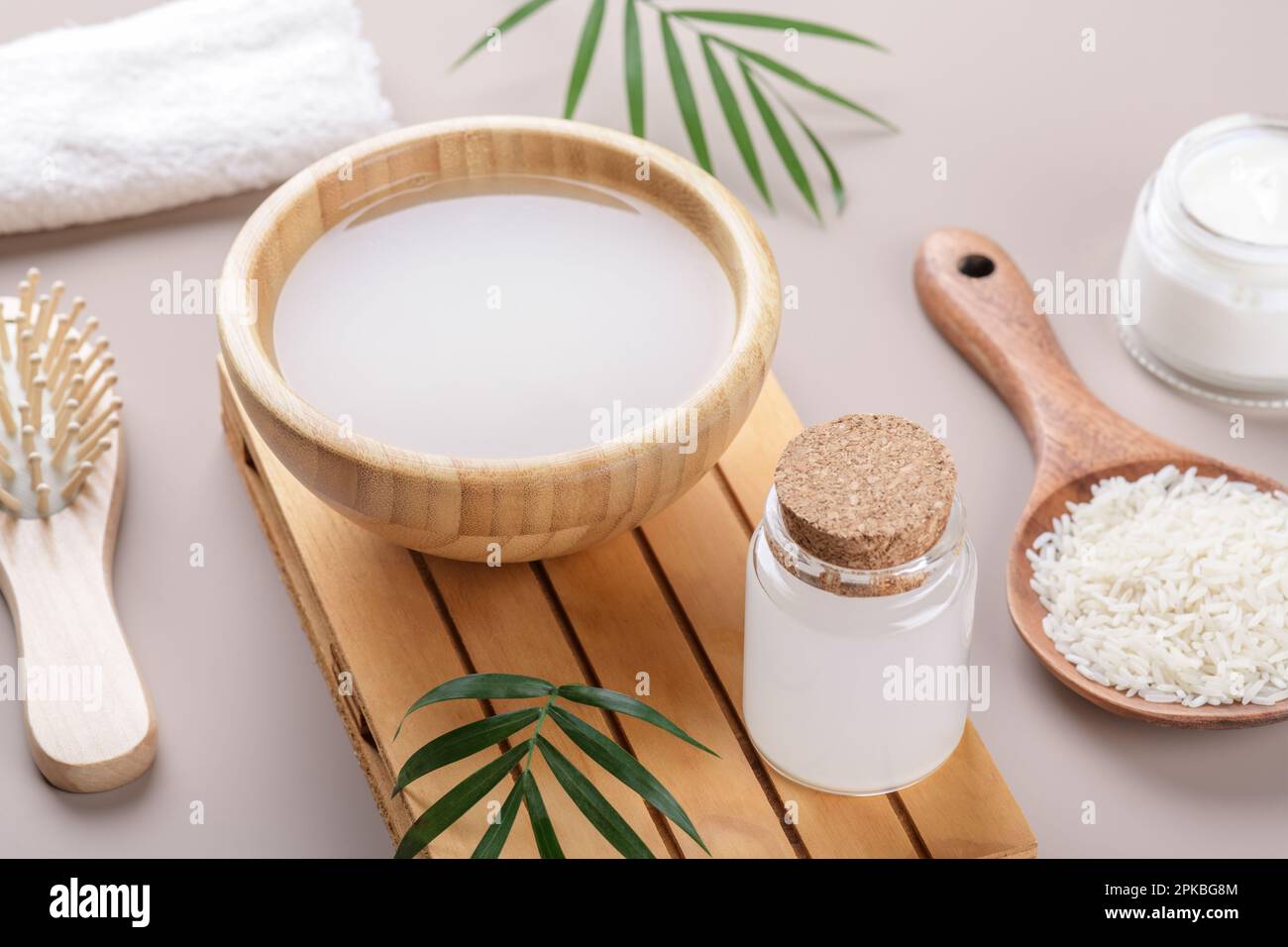 Homemade cosmetic rice water with ingredients and beauty kit on beige ...