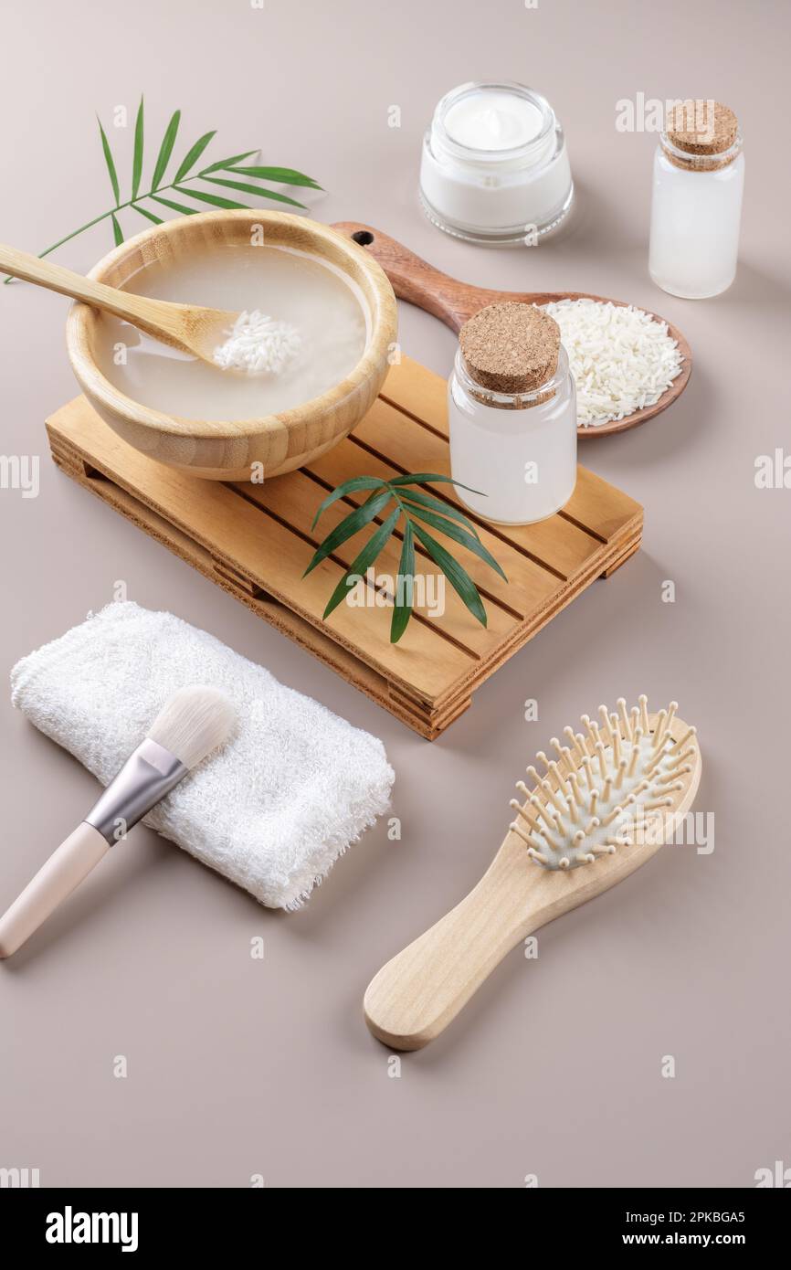 Homemade cosmetic rice water with ingredients and beauty kit on beige ...