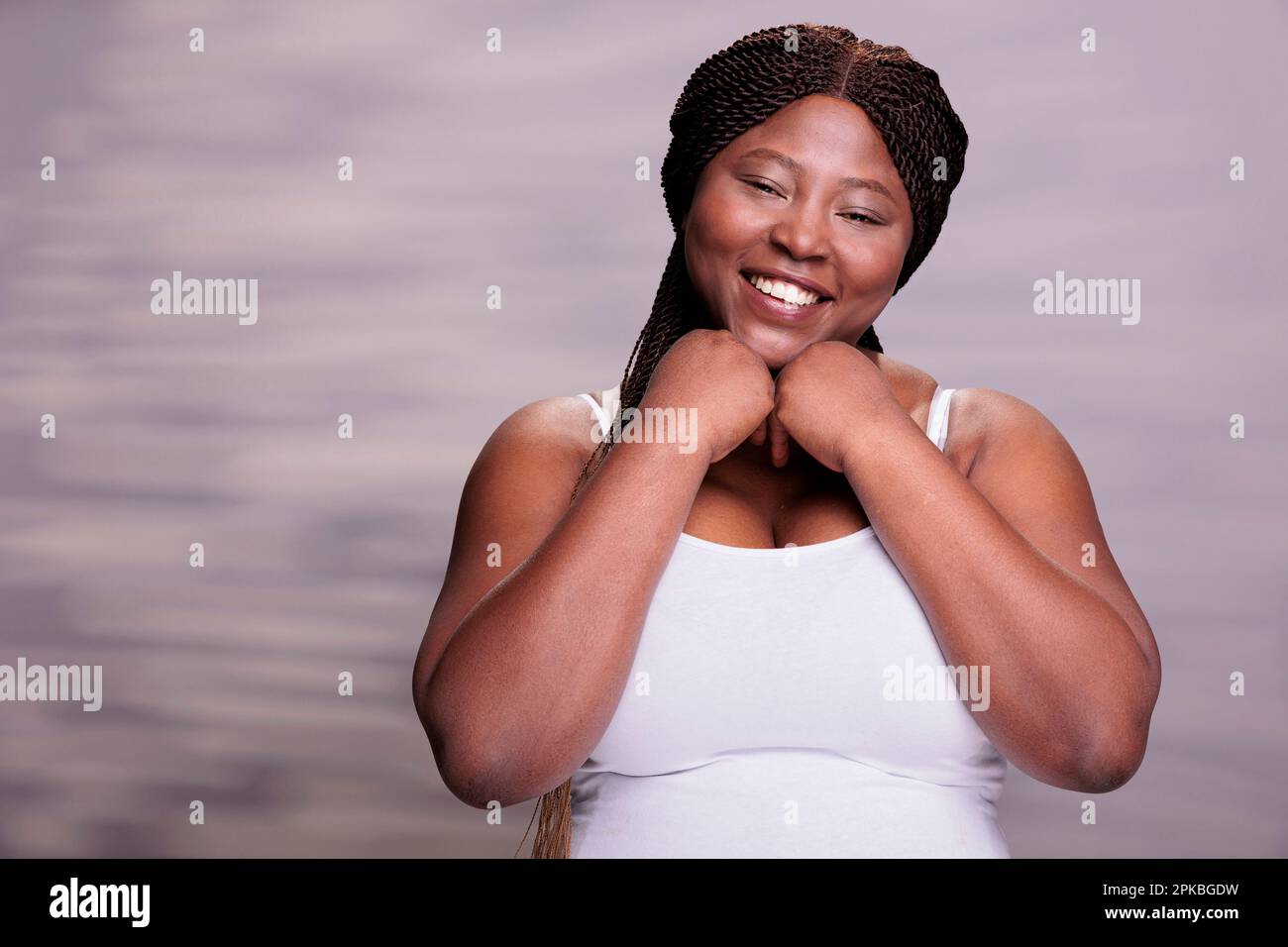 Smiling African American Body Positive Woman Holding Hands Under Chin