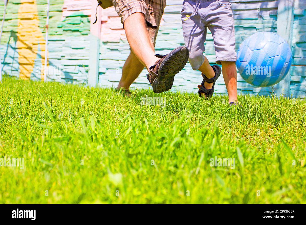 son plays football with dad on the grass Stock Photo - Alamy