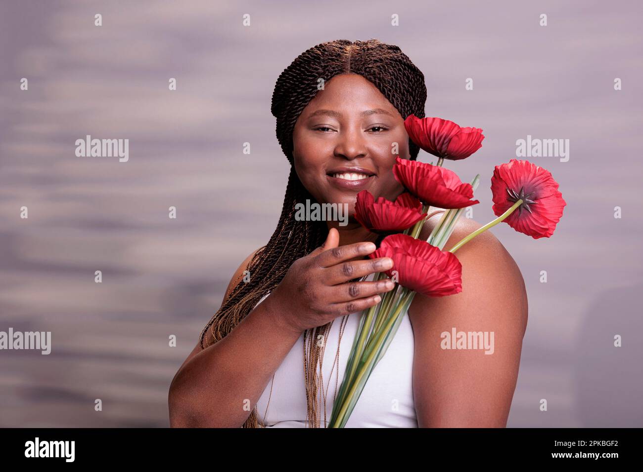 Smiling pretty woman posing with red poppy branch portrait. Young plus ...