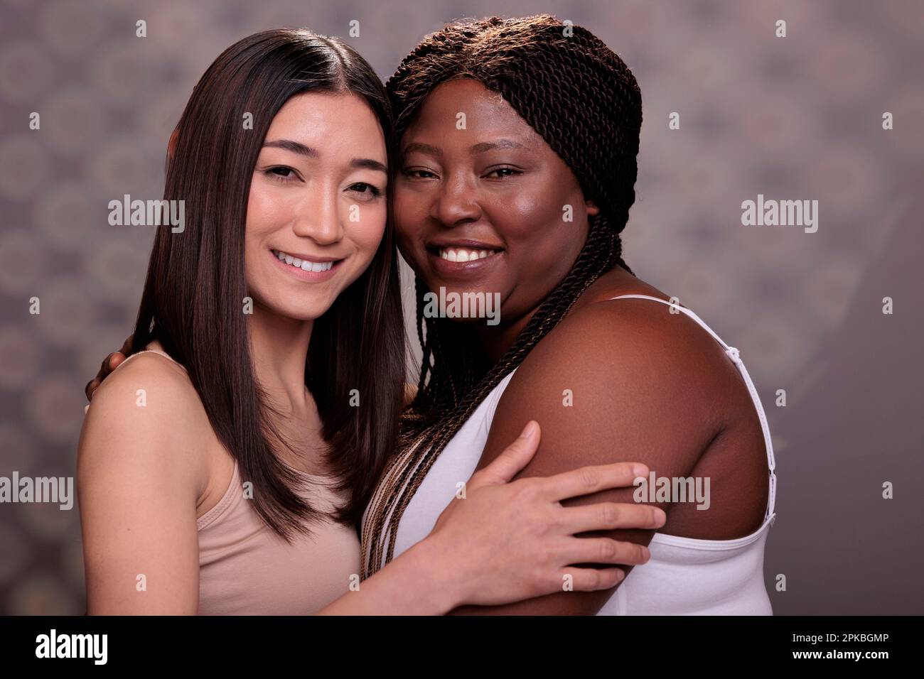 Two diverse women hugging demonstrating confidence, love and self care. Beautiful african ...