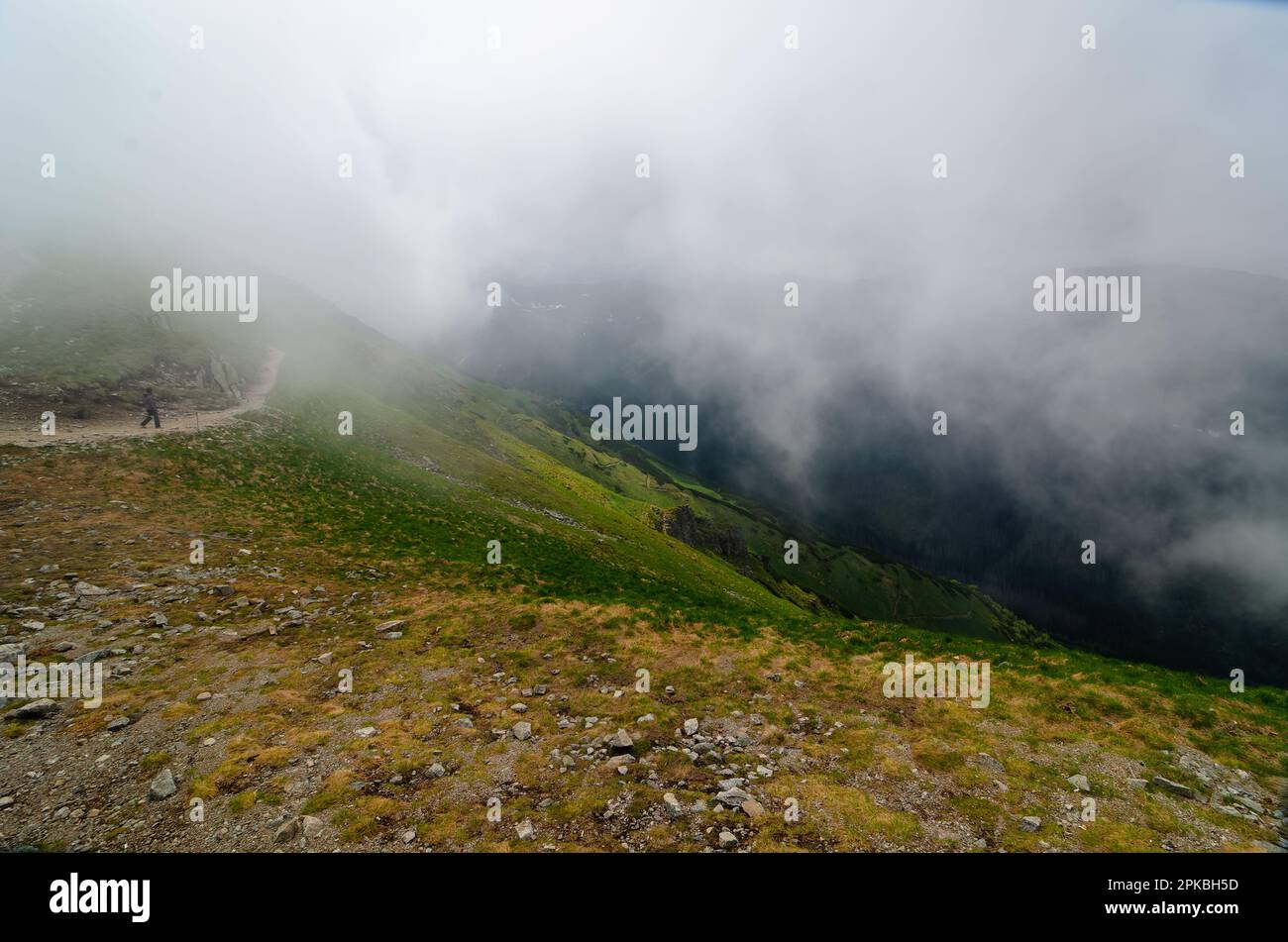 One tourist on a mountain trail walks into a cloud Stock Photo - Alamy
