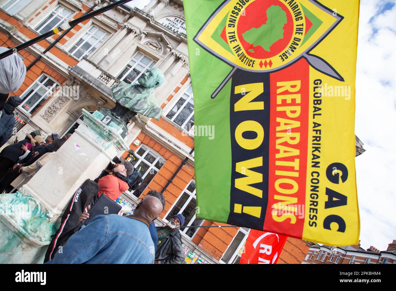 Windrush, UK. 06th Apr, 2023. A man holds a flag calling for ...