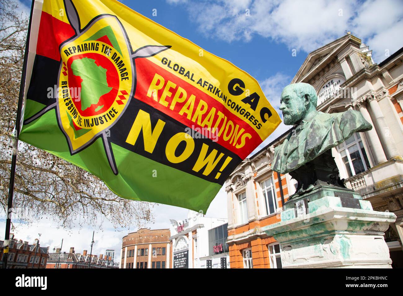 Windrush, UK. 06th Apr, 2023. A man holds a flag calling for ...