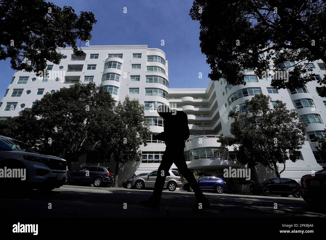 A pedestrian walks across the street from the building where a ...
