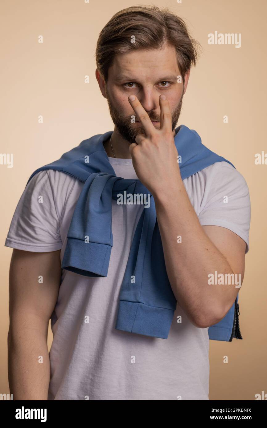 I am watching you. Young confident caucasian man pointing at his eyes ...