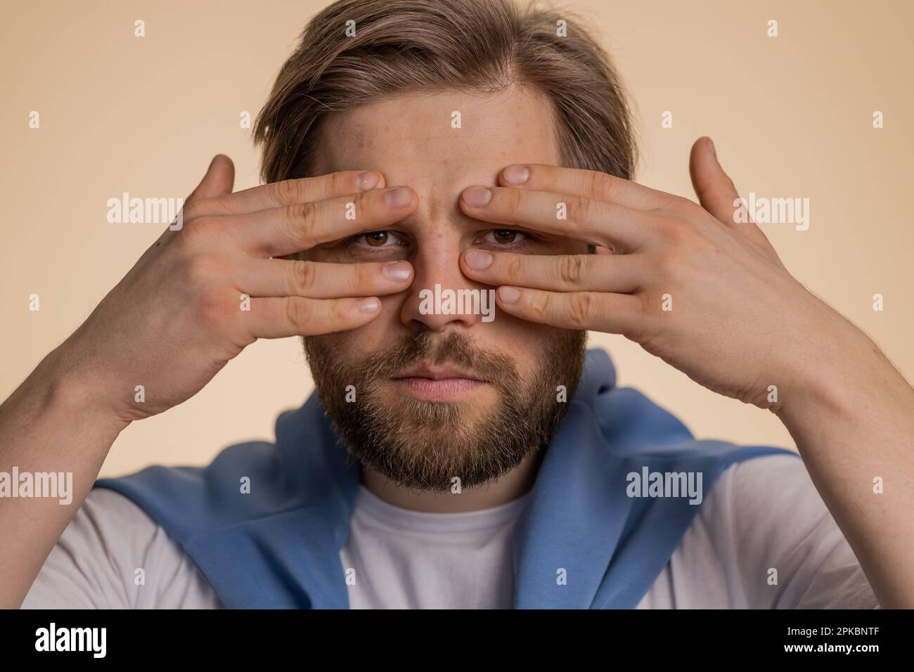 Nosy curious caucasian man closing eyes with hand and spying through ...