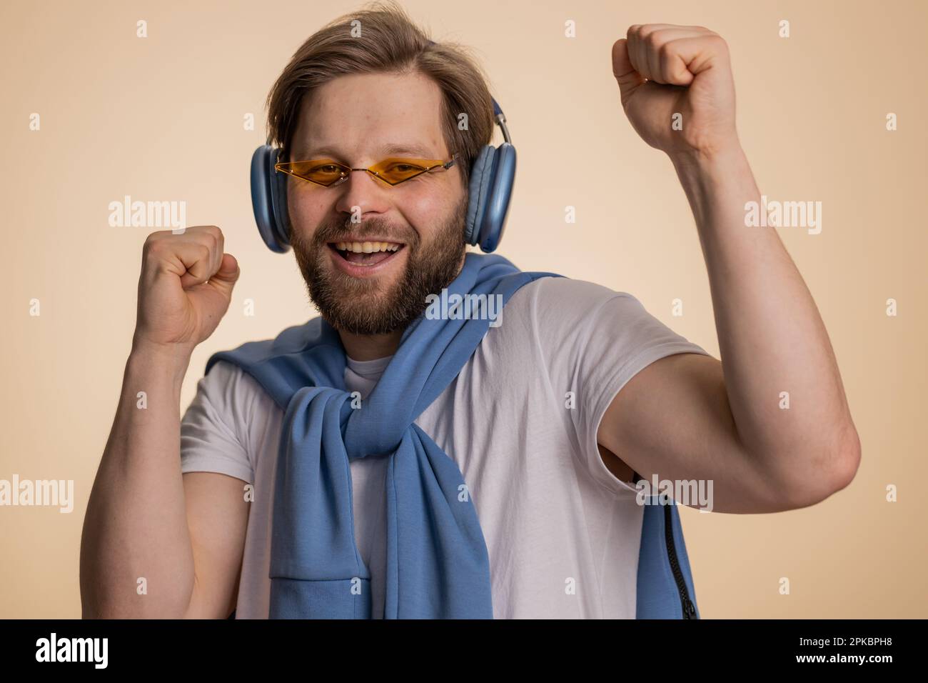 Young happy man listening music via headphones and dancing disco ...