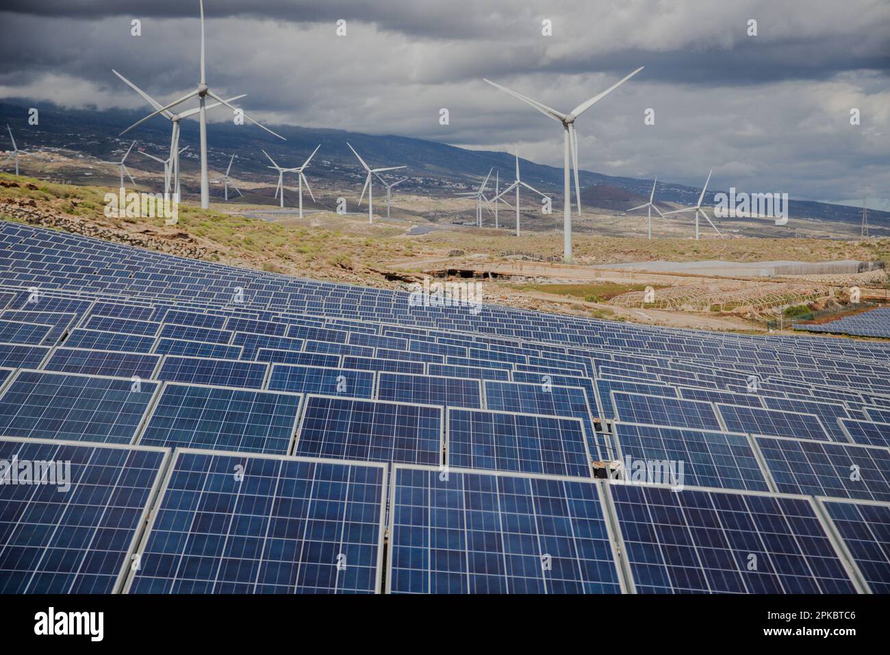 A solar power plant with solar panels and wind turbines, producing ...