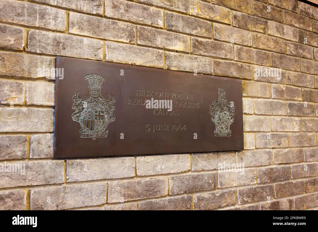 Brass wall plaque with the motto 'felix qui potuit rerum cognoscere ...