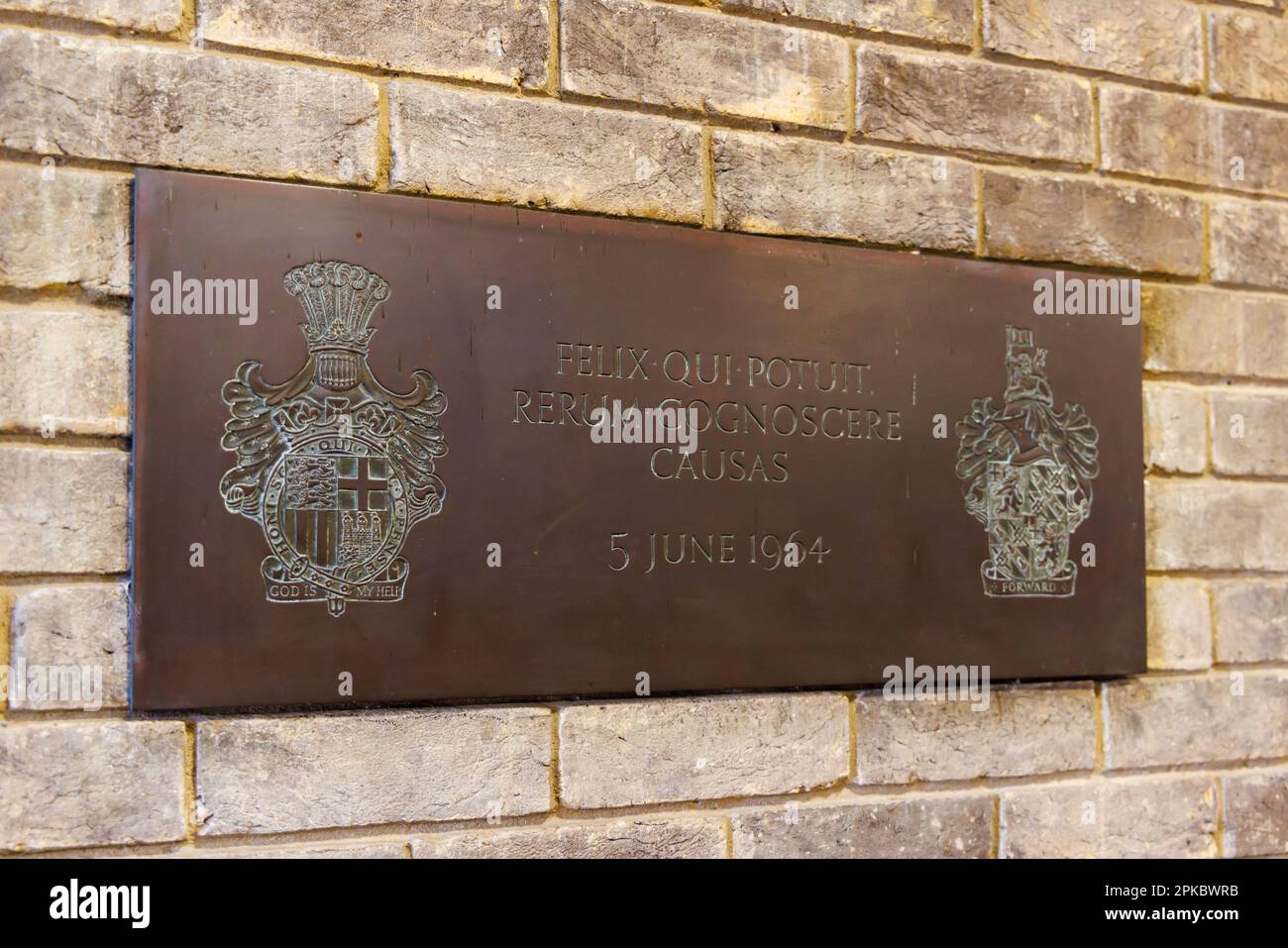 Brass wall plaque with the motto 'felix qui potuit rerum cognoscere ...