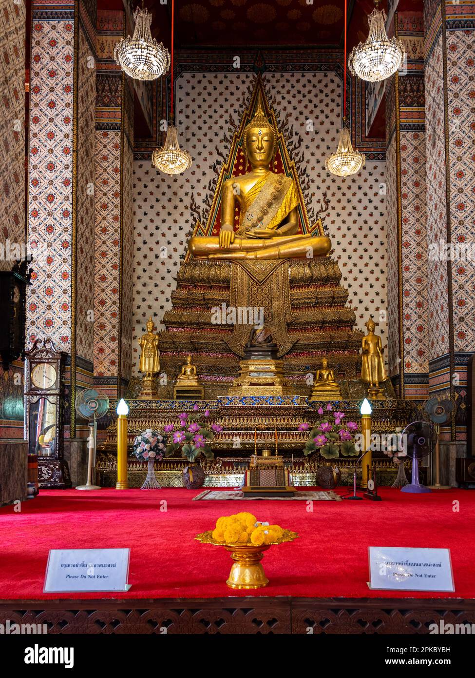 A stunning Golden Buddha statue seated on a throne adorned with ...