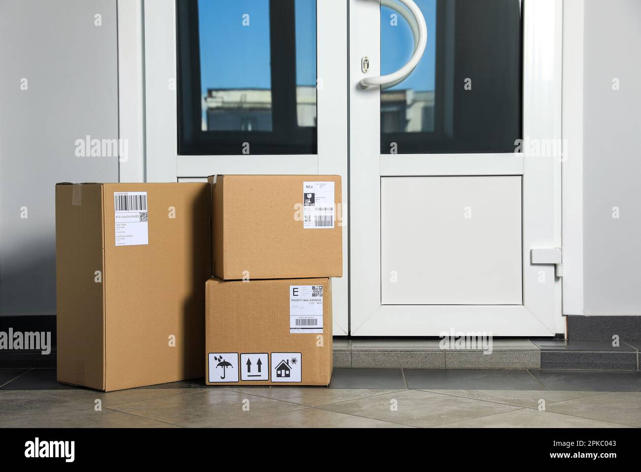 Cardboard boxes on floor near entrance. Parcel delivery service Stock ...