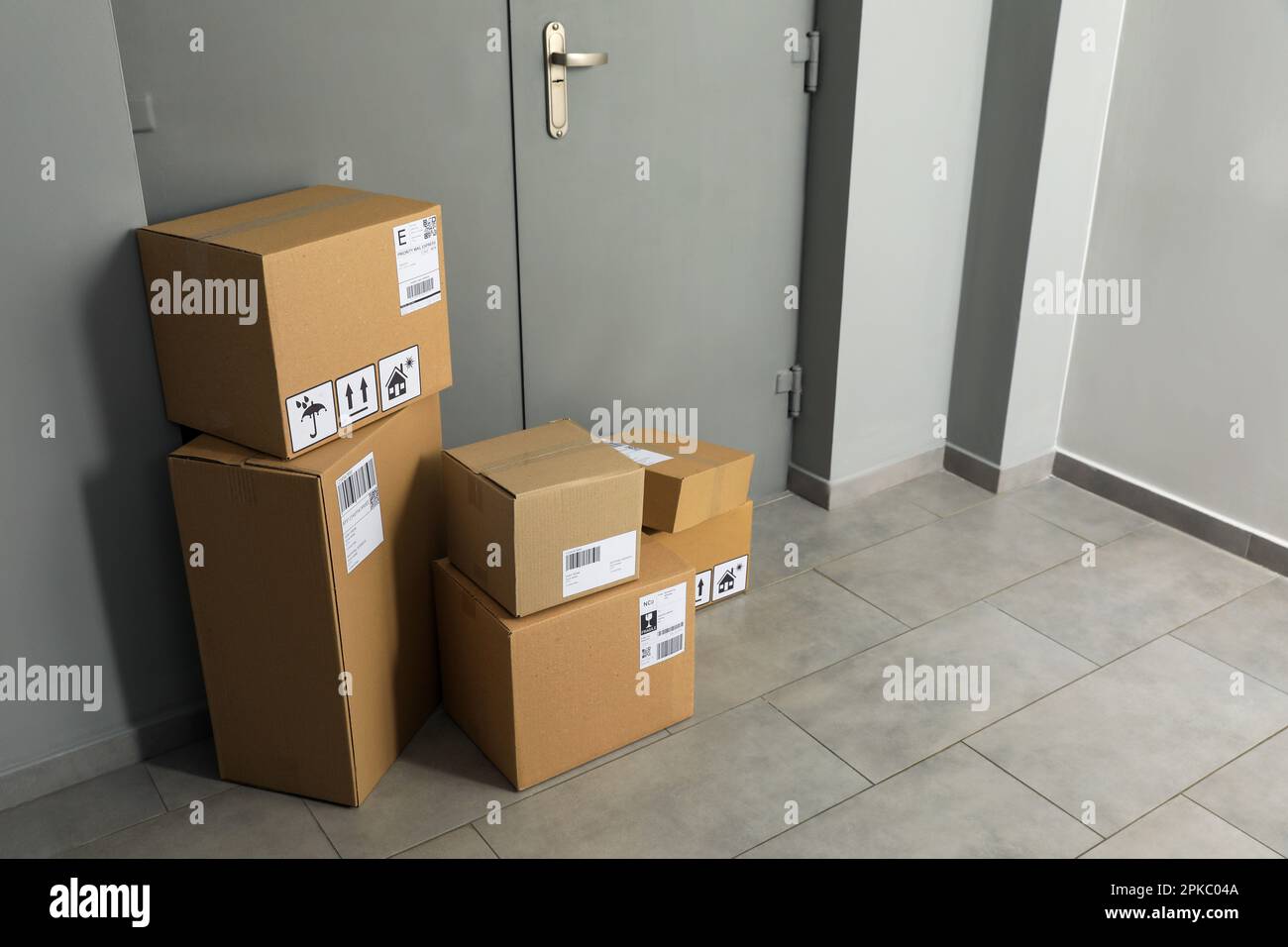 Cardboard boxes on floor near entrance. Parcel delivery service Stock ...
