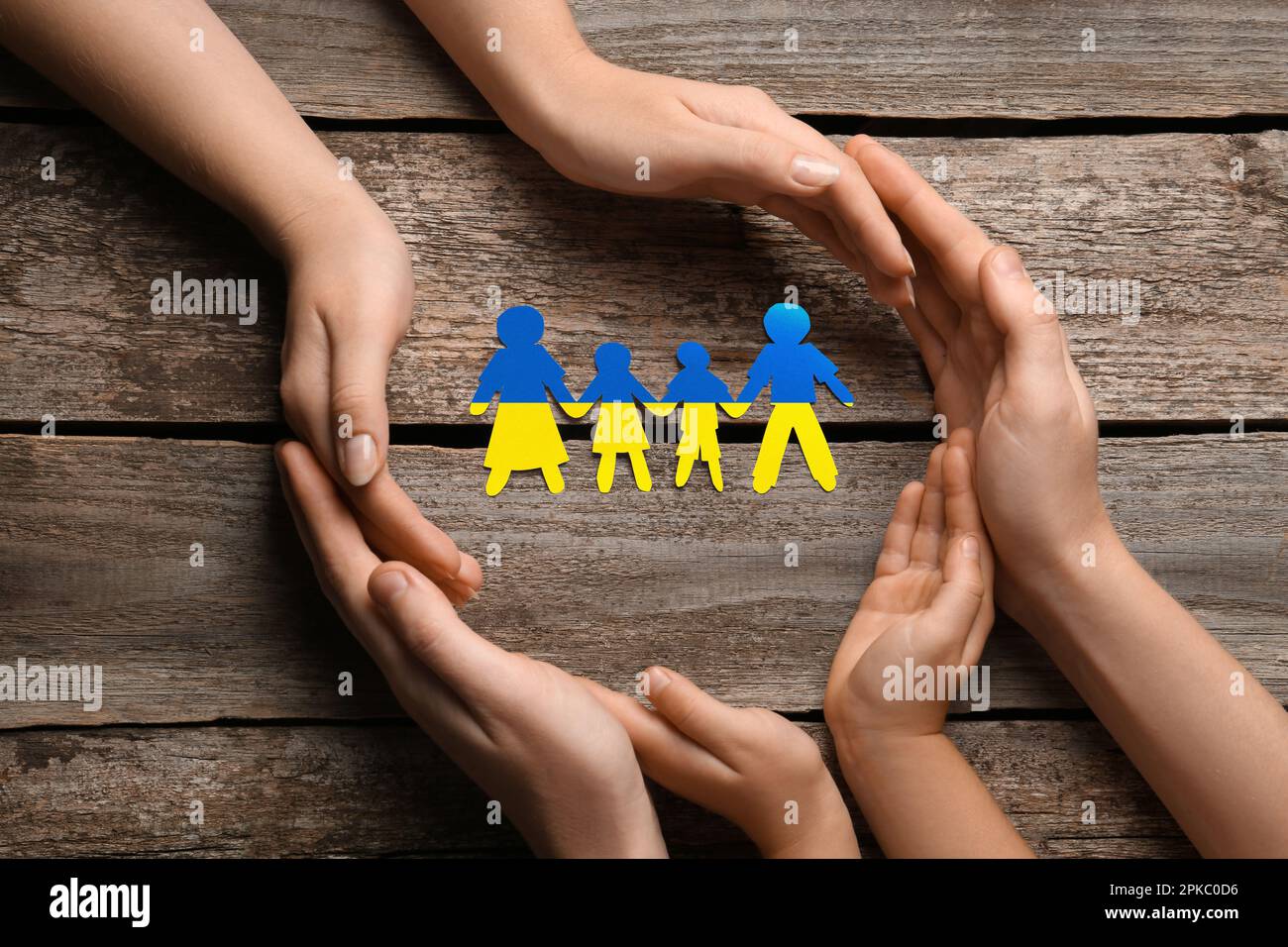 Parents and child protecting paper family cutout in colors of Ukrainian ...