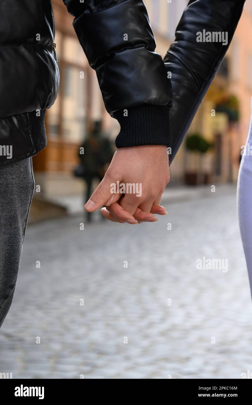 Lovely couple holding hands together outdoors, closeup. Romantic date ...