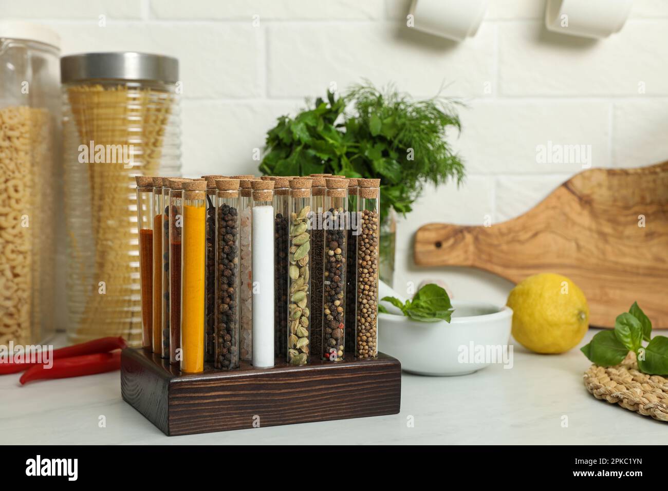 Glass tubes with different spices on kitchen counter Stock Photo - Alamy