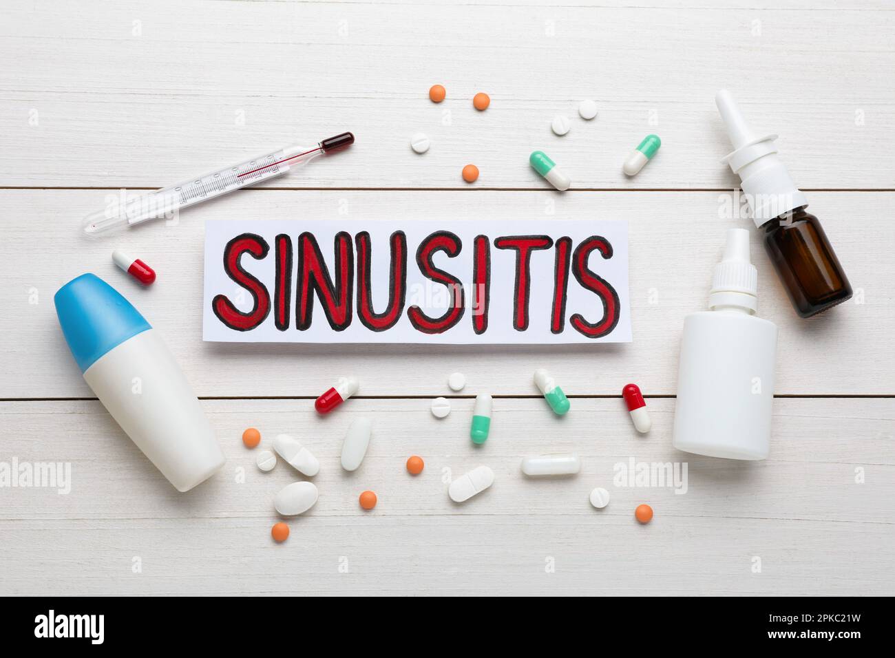 Card with word SINUSITIS, thermometer and different drugs on white ...