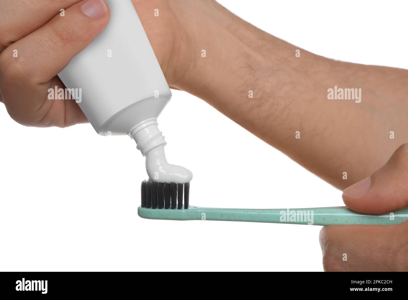Man applying toothpaste on brush against white background, closeup ...