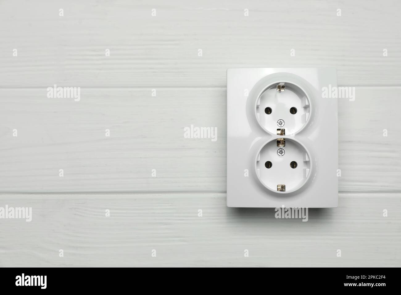 Modern plastic power socket on white wooden table, top view. Space for ...
