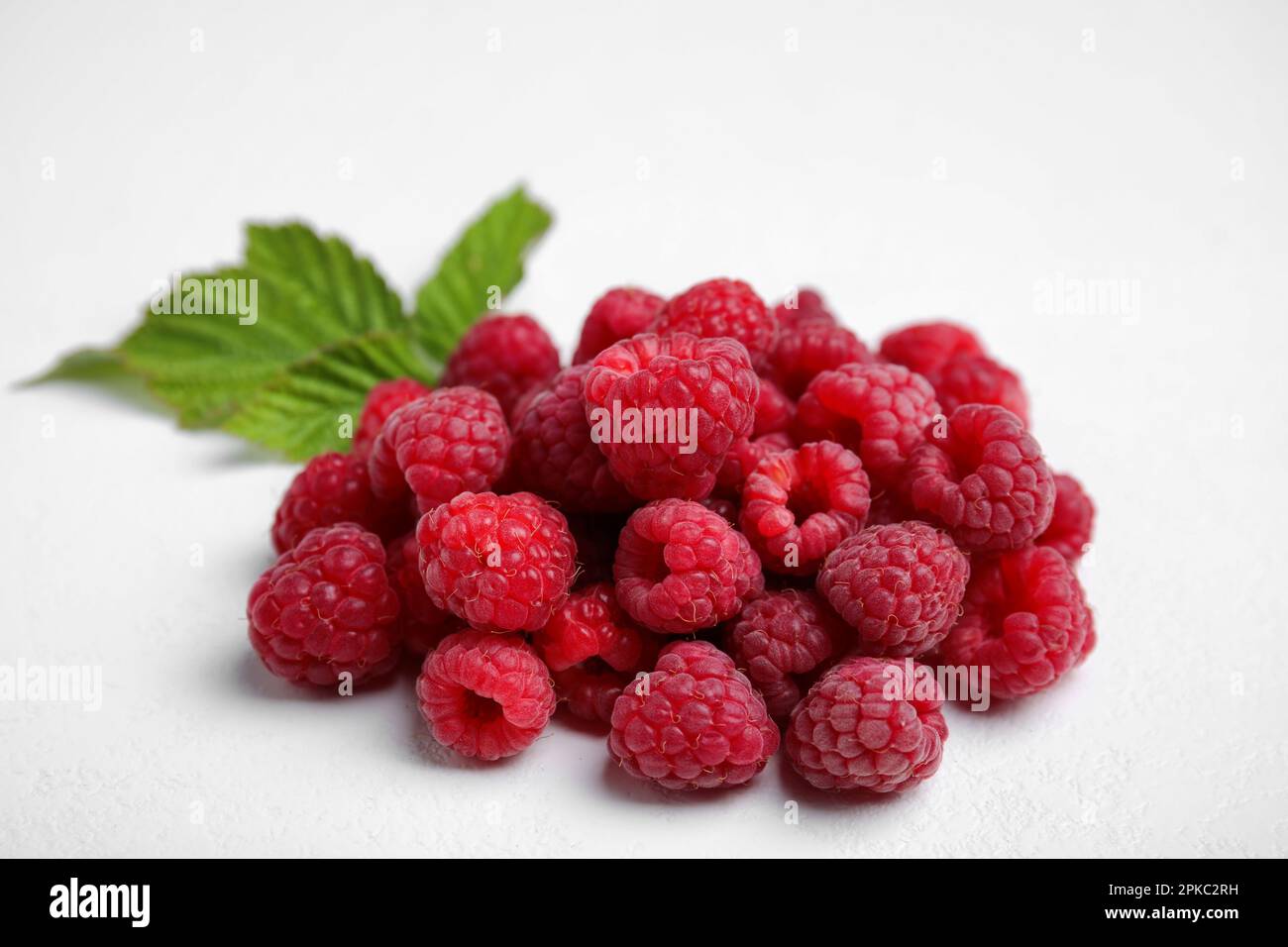Fresh red ripe raspberries with green leaves on white background Stock ...
