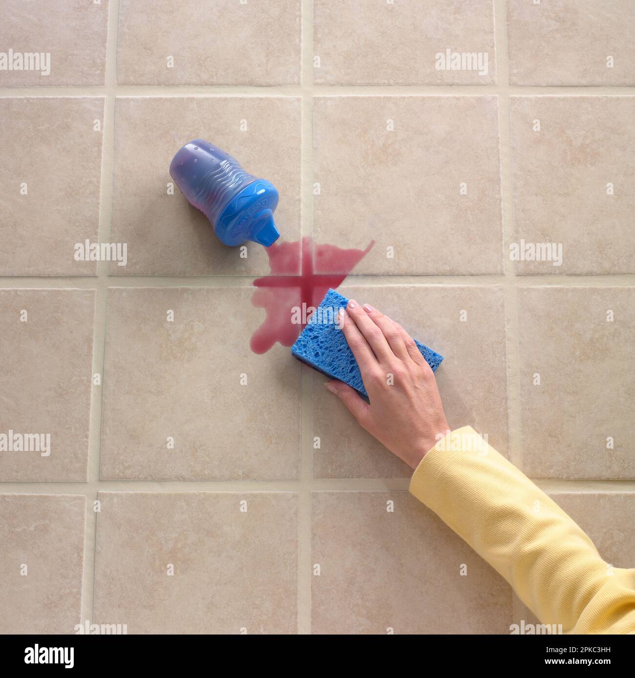 woman's hand holding blue sponge wipes up spilled juice wine on tile ...