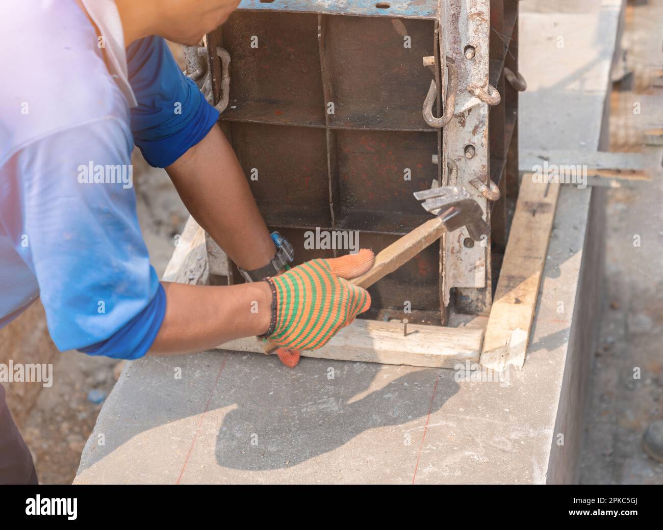 Worker hammering a nail into a plank, formwork installation at ...