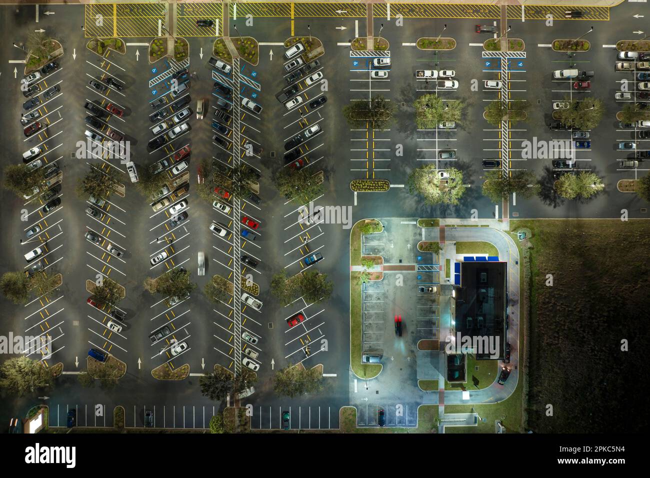 Aerial night view of many cars parked on parking lot with lines and ...