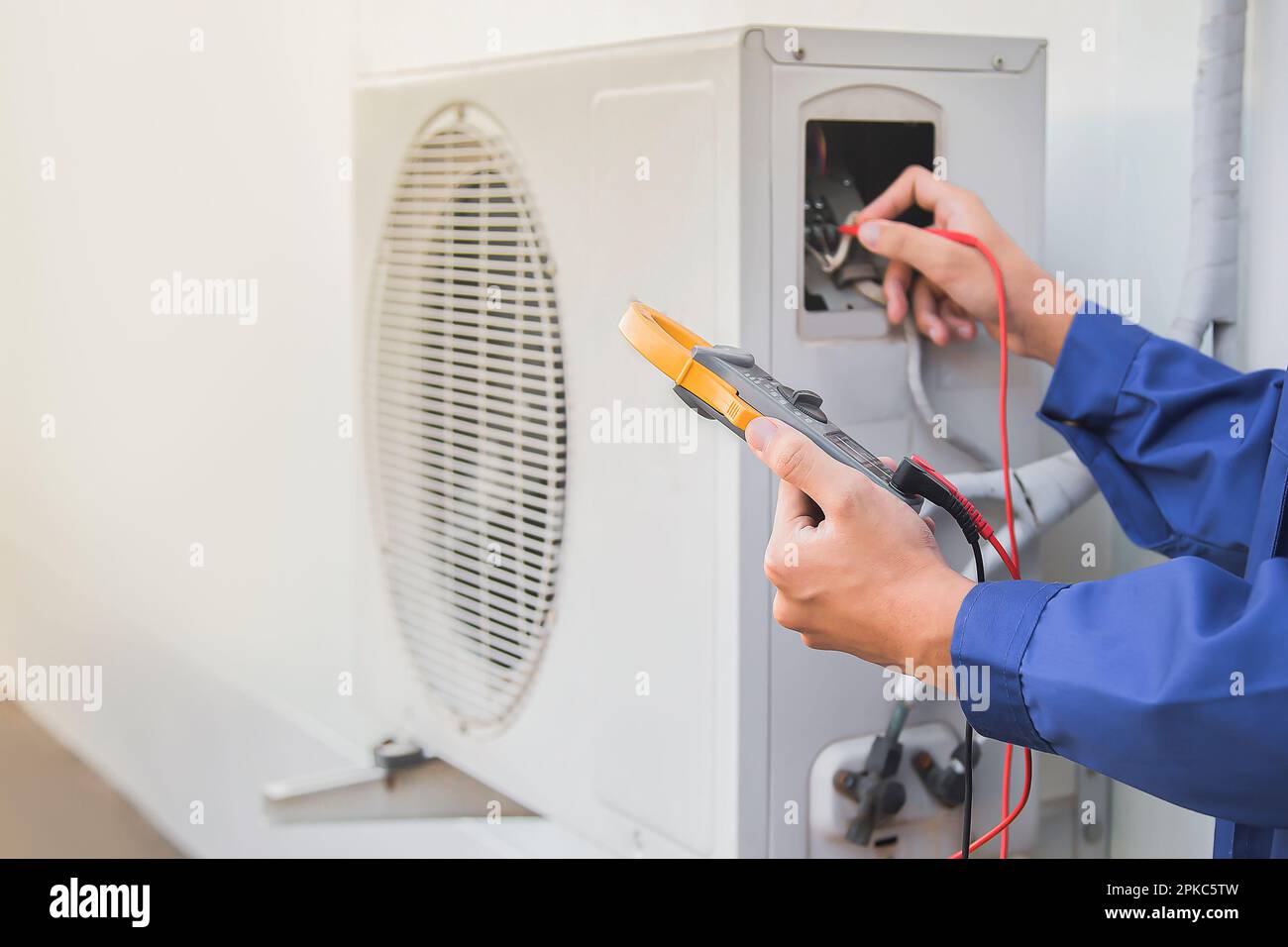Air conditioner repairman using electricity meter to check air ...
