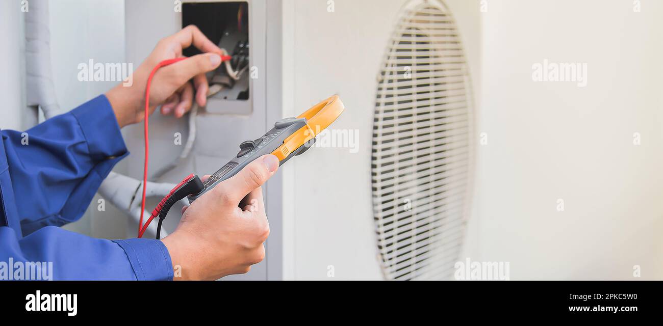 Air conditioner repairman using electricity meter to check air ...