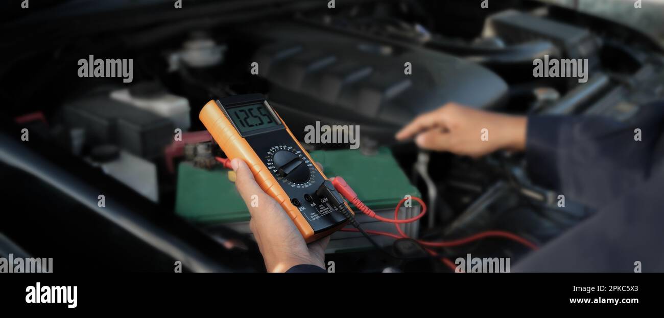 A technician is checking the car battery for availability Stock Photo ...