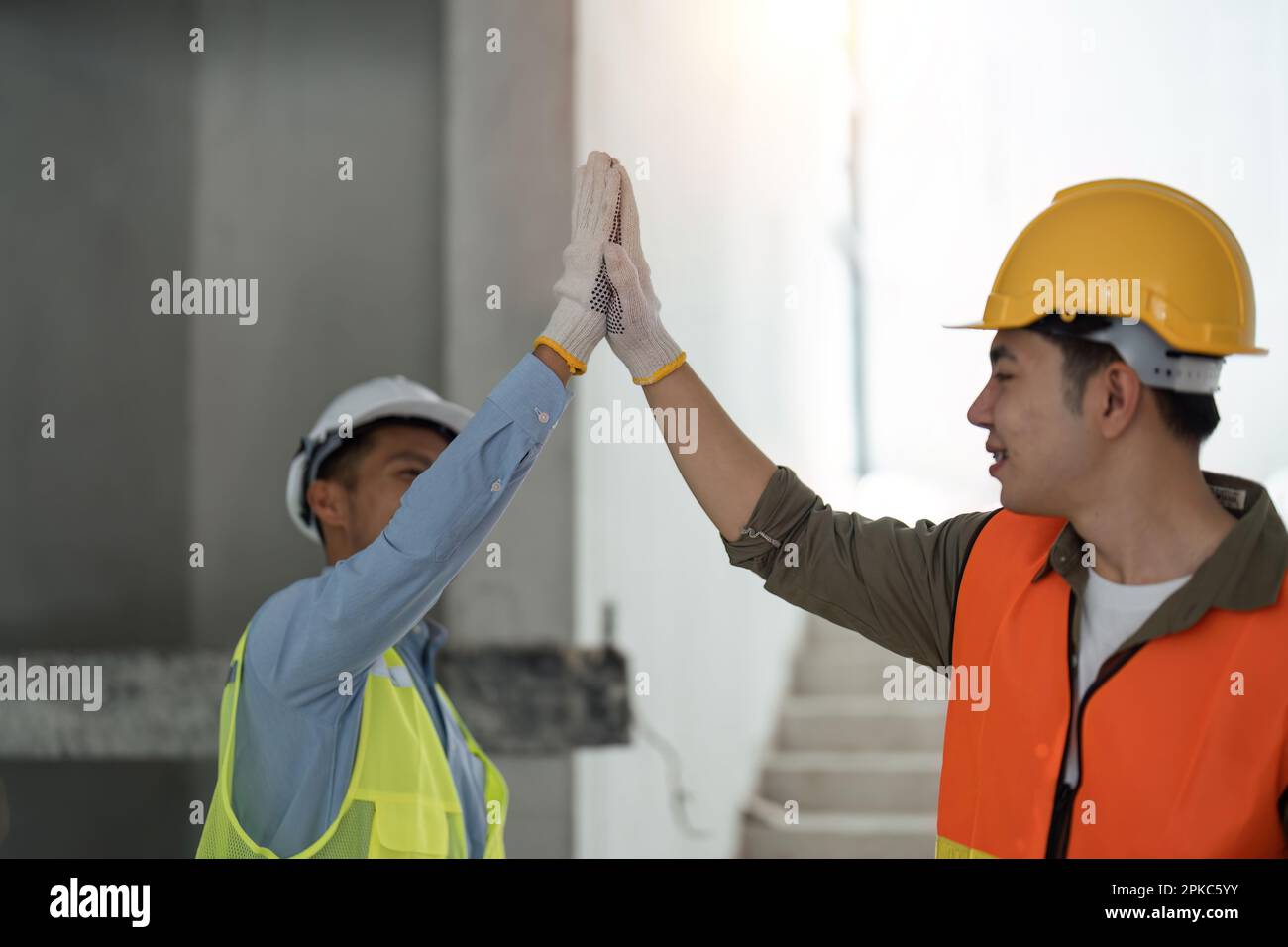 Engineer a high five to his friend colleague in the construction site ...