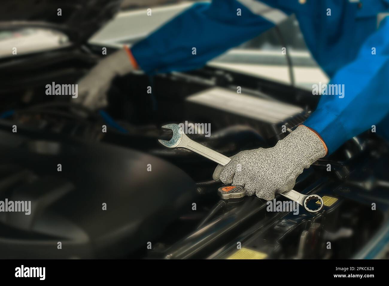 The mechanic works on the engine of the car in the garage, car repair ...