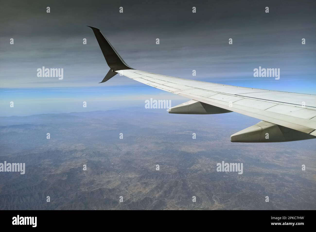 View through airplane window of commercial jet plane wing flying high ...