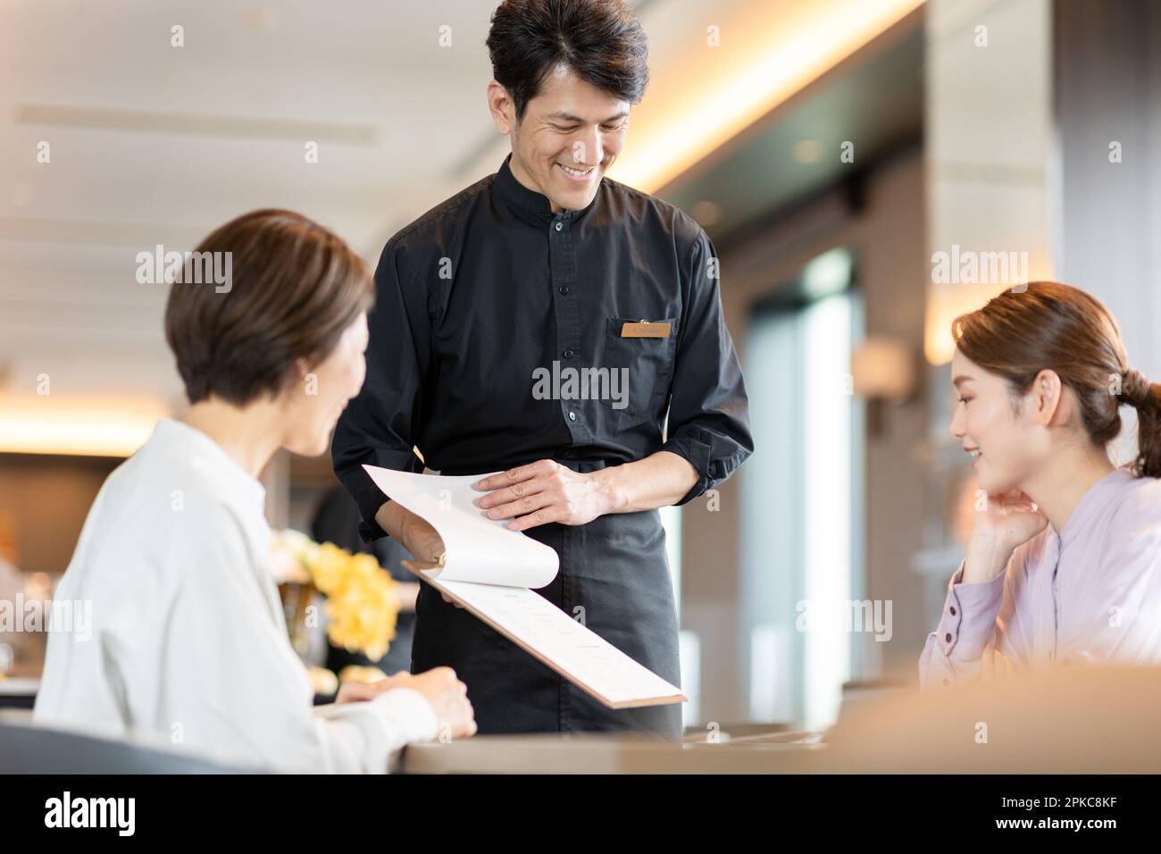 Restaurant staff showing a menu Stock Photo - Alamy