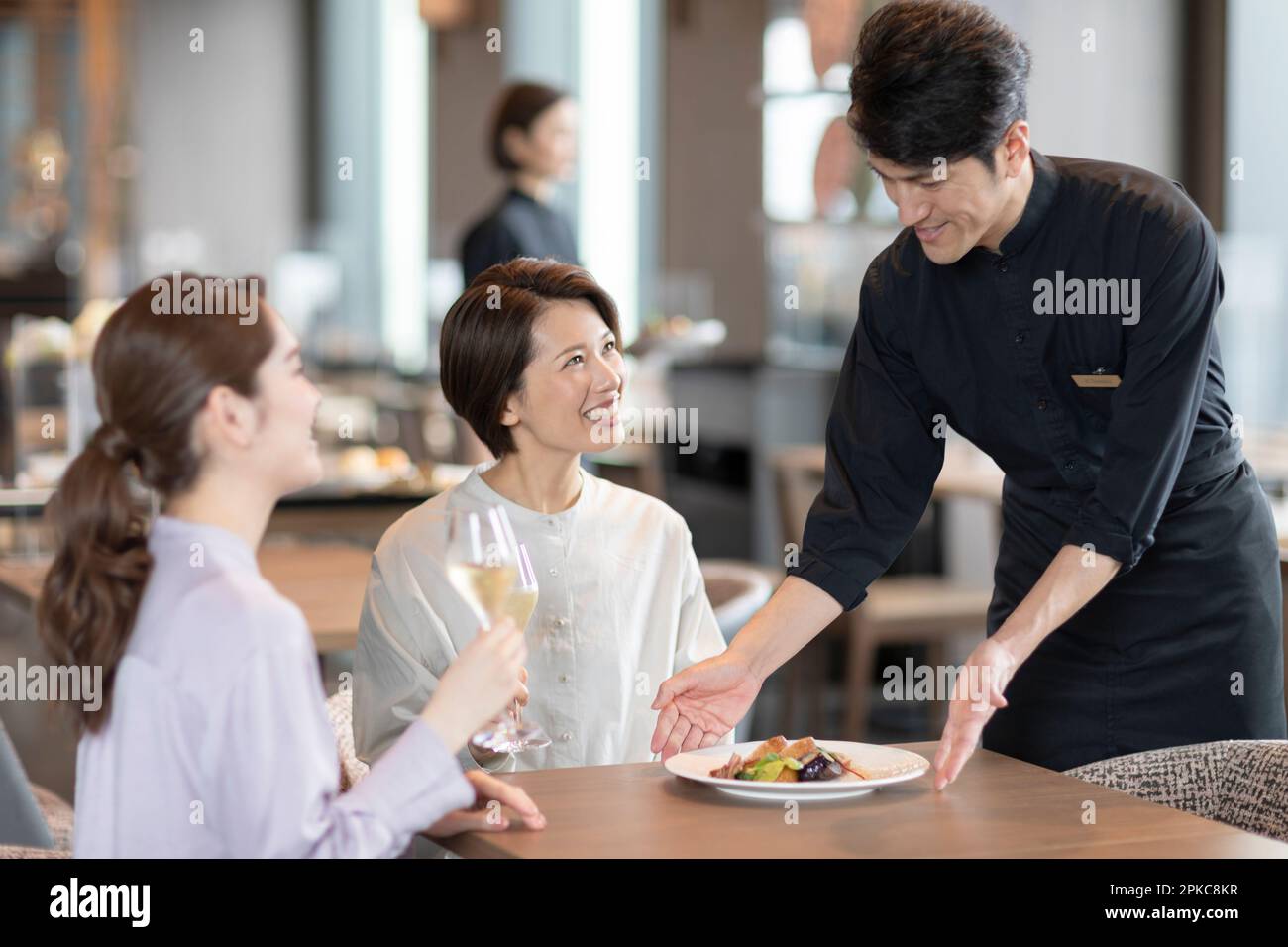 A staff member serving a meal Stock Photo - Alamy