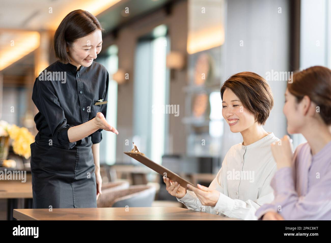 Restaurant staff showing the menu Stock Photo - Alamy