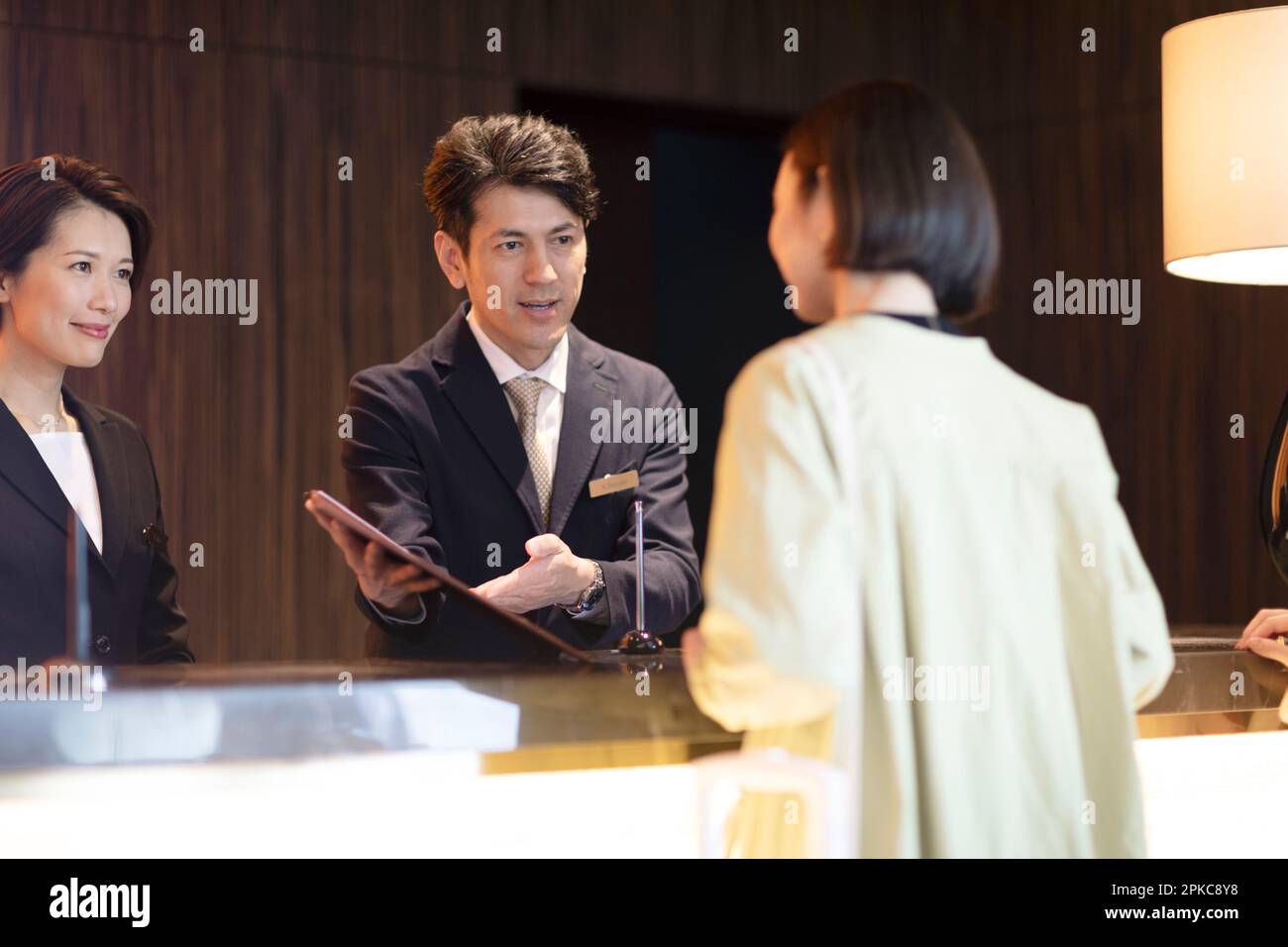 Front desk staff dealing with customers Stock Photo - Alamy