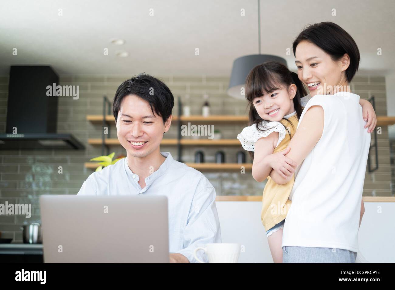 Family members looking at computers Stock Photo - Alamy