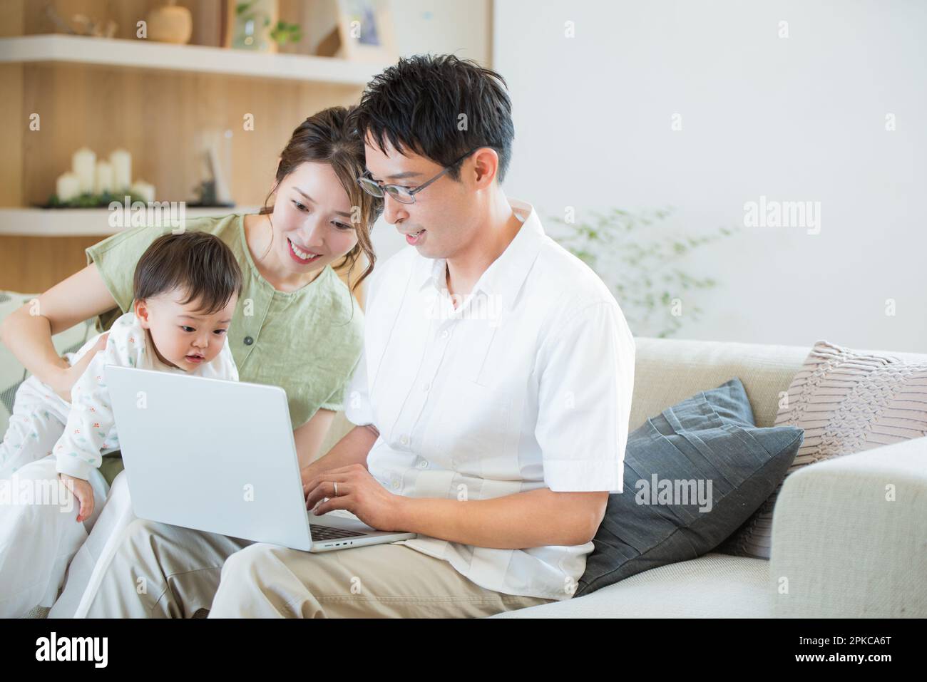 Parent and child watching computer on sofa Stock Photo - Alamy