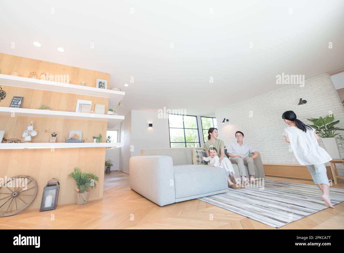 Family watching over their daughter as she frolics in the living room ...