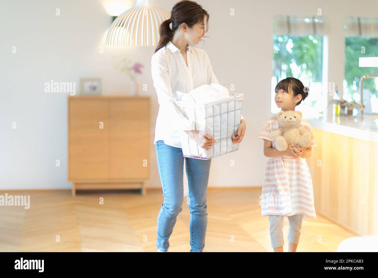 Parent and child happily carrying laundry Stock Photo - Alamy