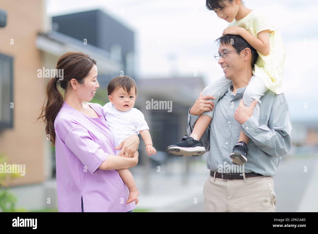 Baby being carried by mother and girl being carried by father Stock ...