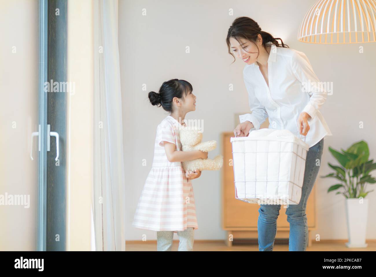 Parent and child happily carrying laundry Stock Photo - Alamy